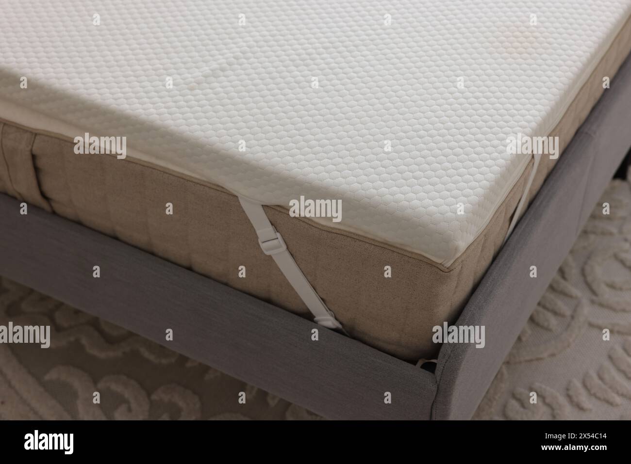 White memory foam mattress topper on grey bed Stock Photo - Alamy