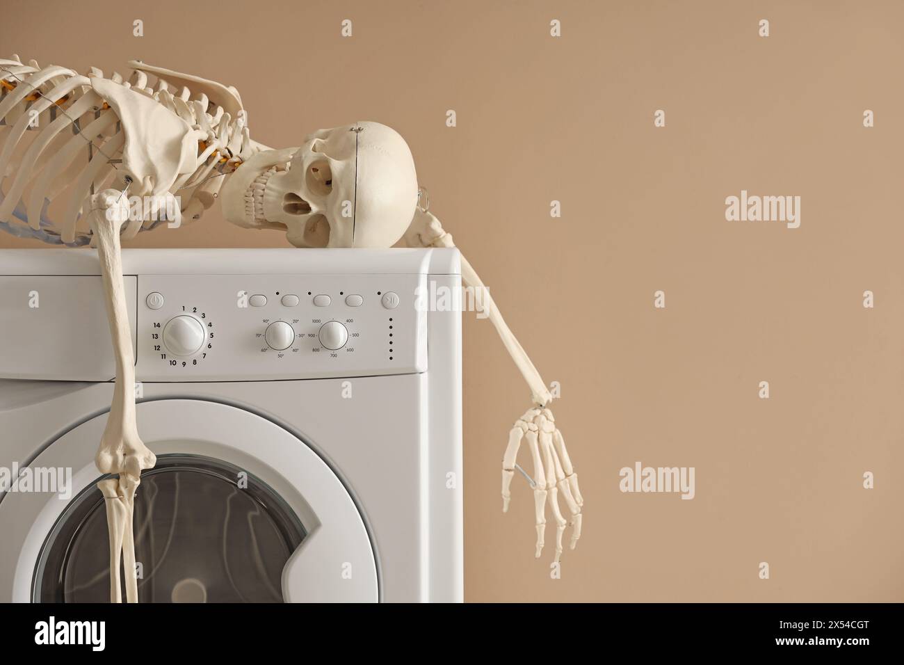 Waiting concept. Human skeleton lying on washing machine near beige ...