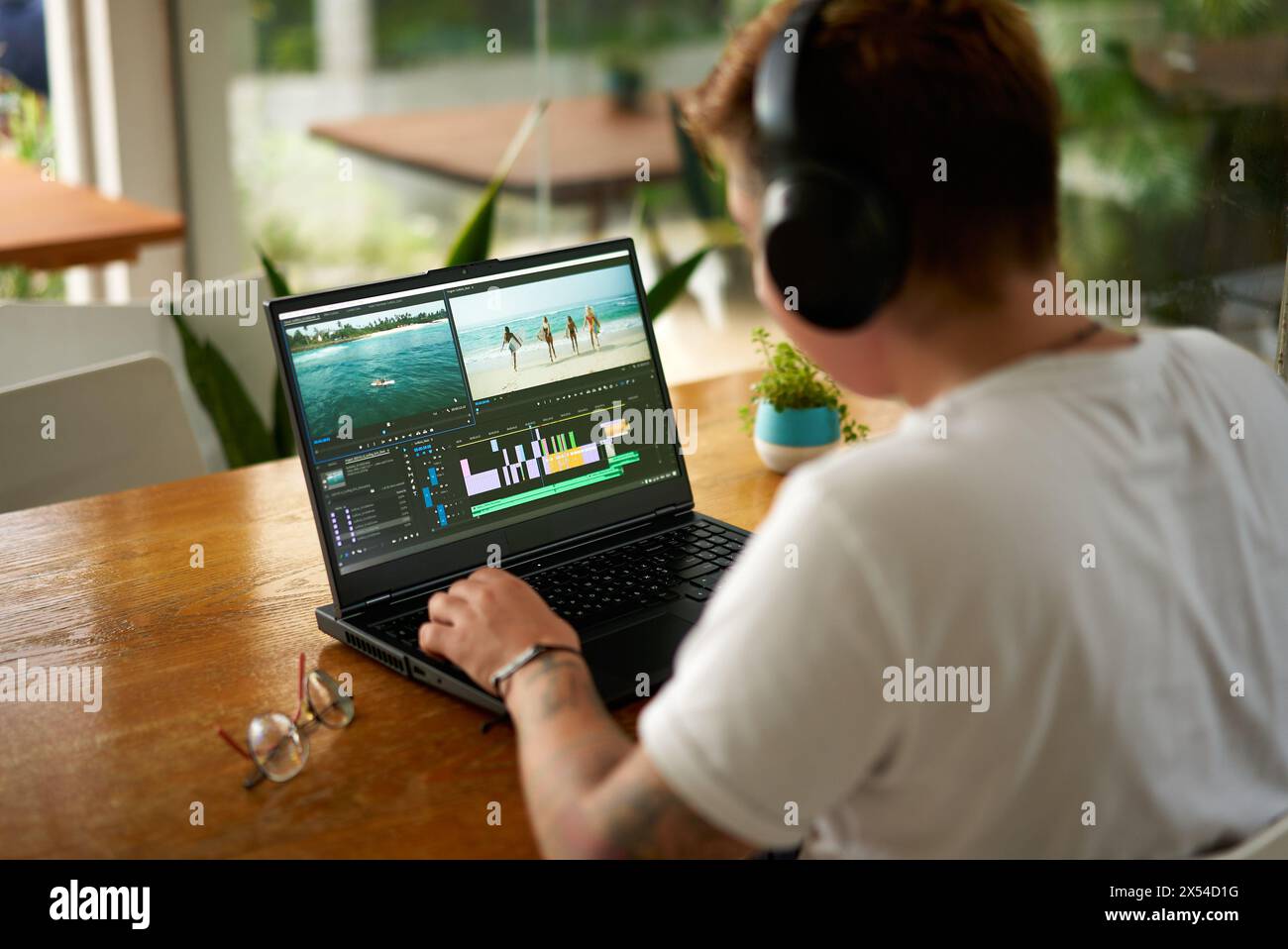 Professional video editor works on laptop with editing software ...