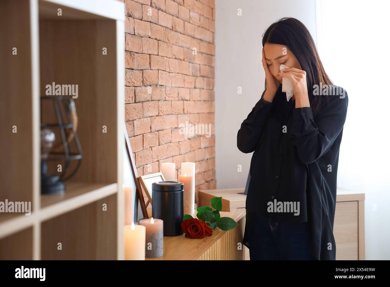 Grieving young Asian woman with mortuary urn crying at funeral Stock ...
