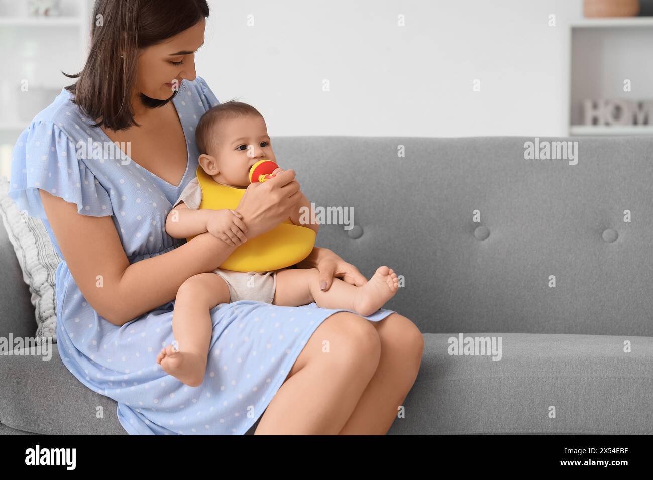 Mother and her little baby with nibbler eating food at home Stock Photo ...