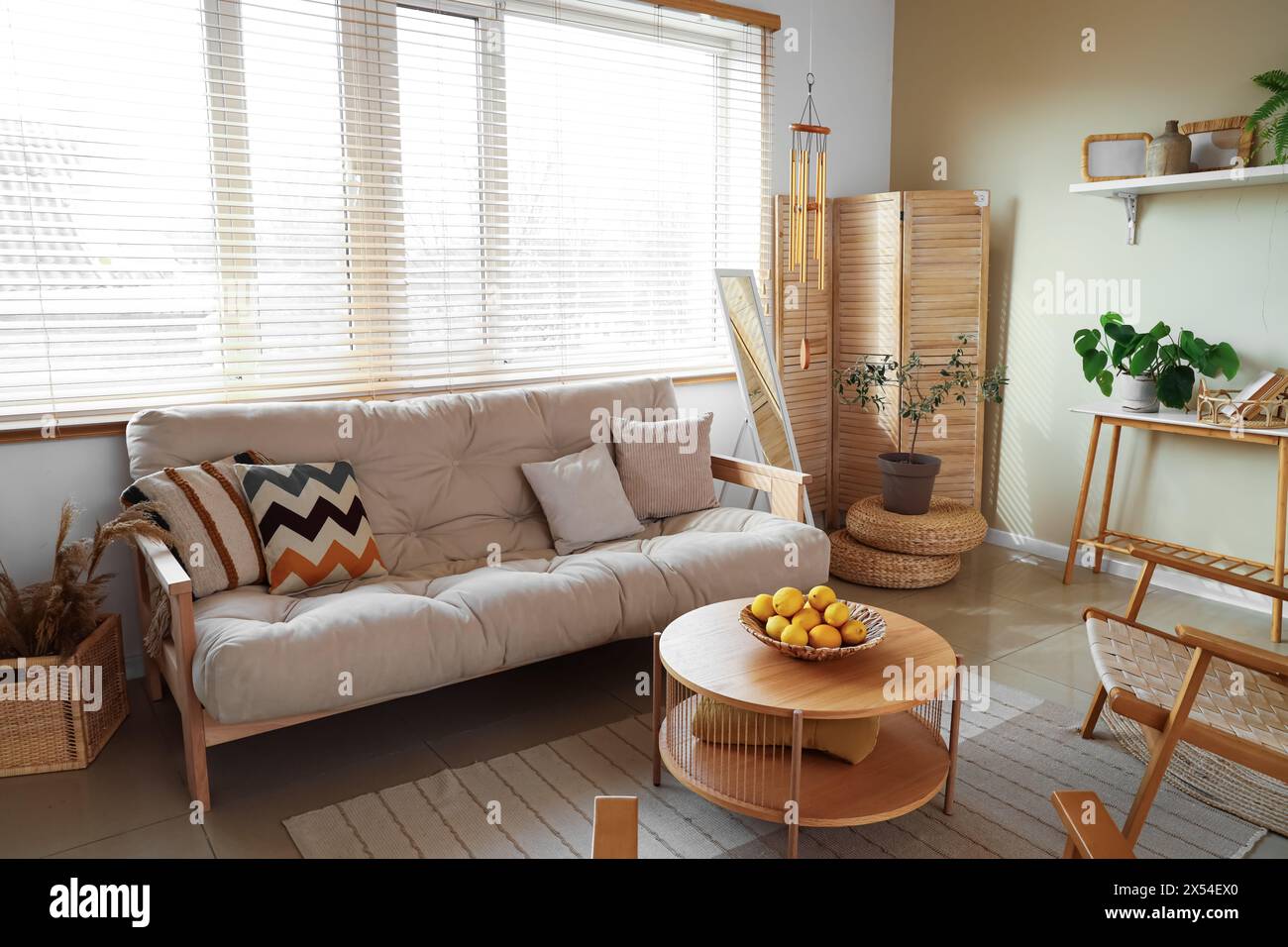 Interior of light living room with wind chime, sofa and table Stock ...