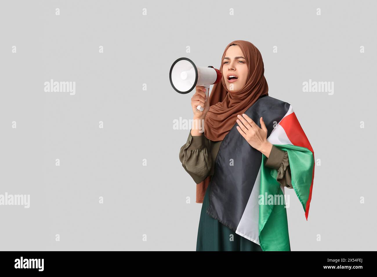Young Muslim woman with Palestine flag and megaphone screaming on grey ...