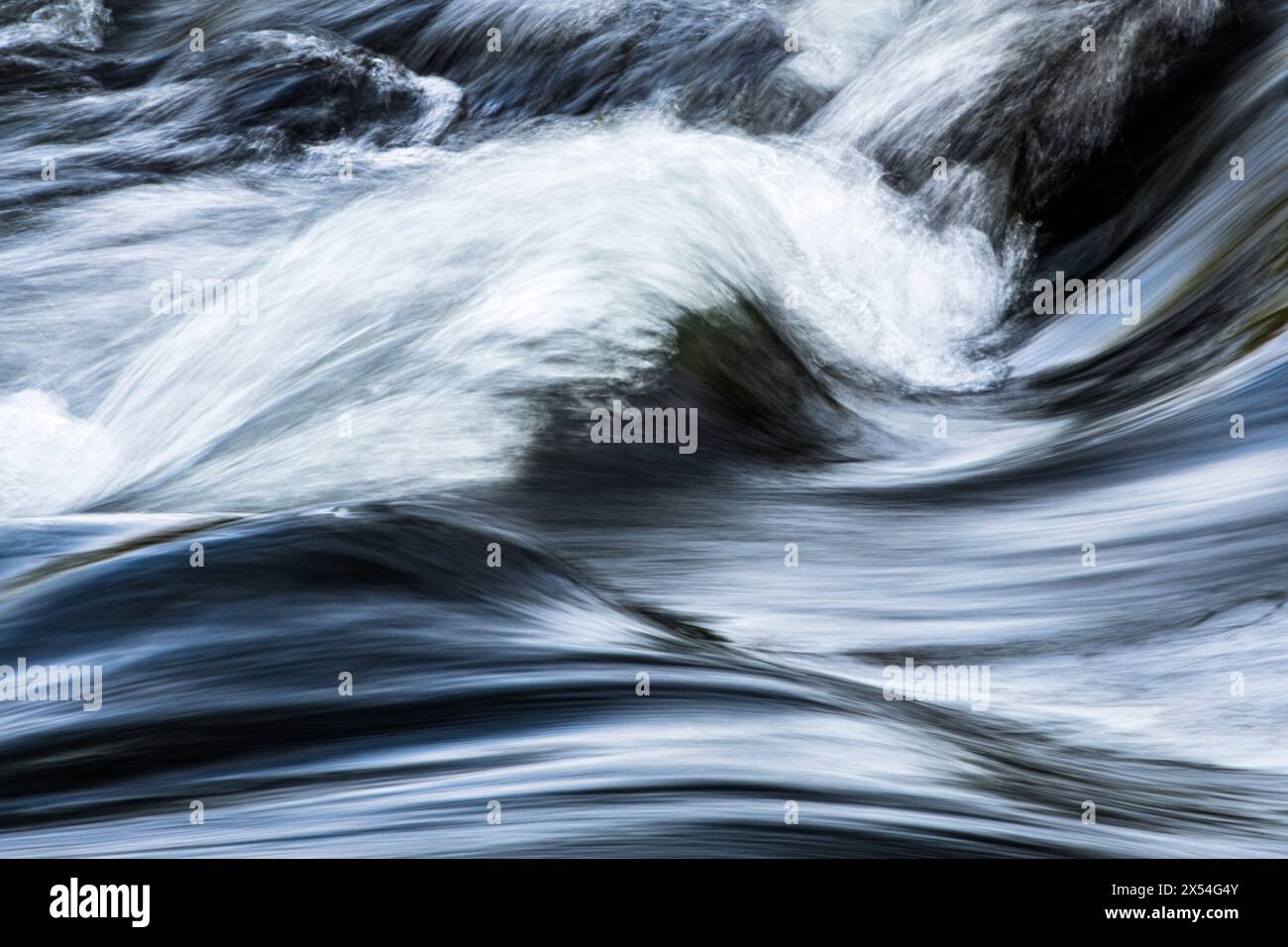 A slow shutter speed adds blur to a photograph of running water in a ...