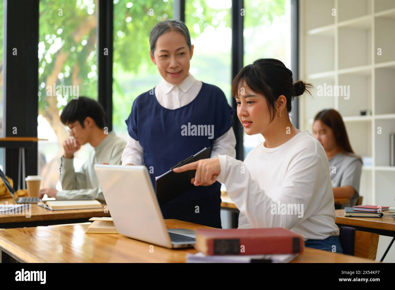 Friendly senior professor helping female student with assignment Stock ...