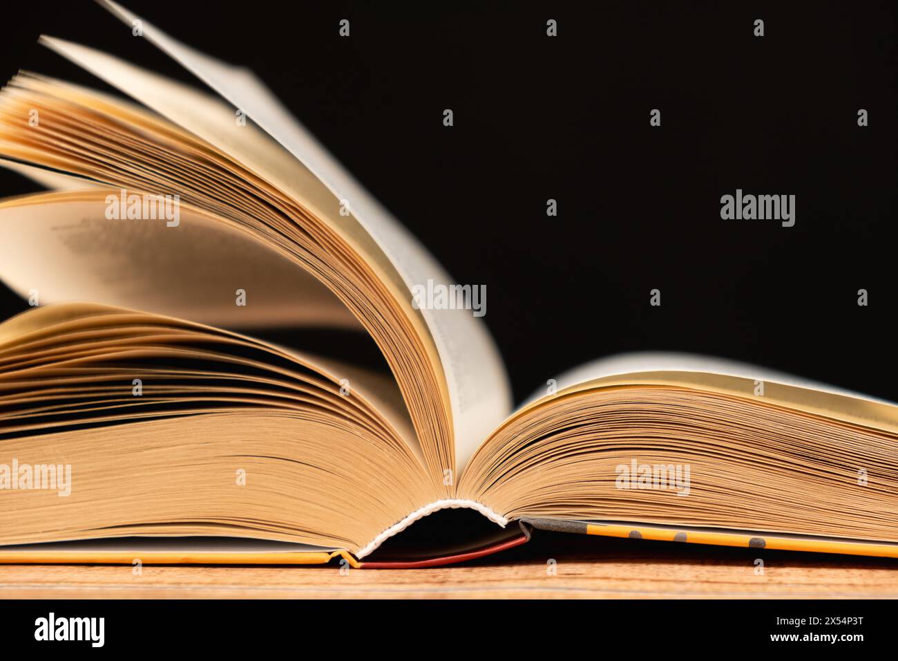 Pages of a thick book are turned on a black background, space for text ...