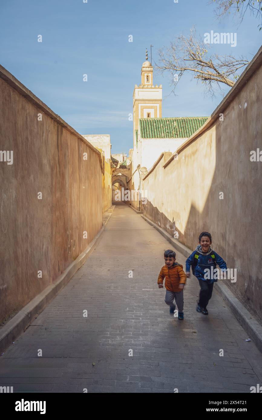 Kids dash along an ancient alleyway against the backdrop of a historic ...