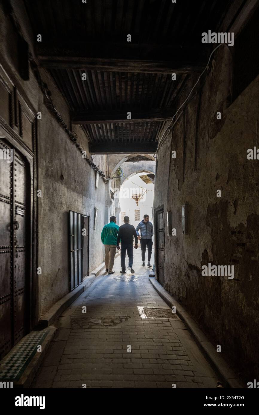 Young men walking down a narrow alleyway in the maze-like streets of ...