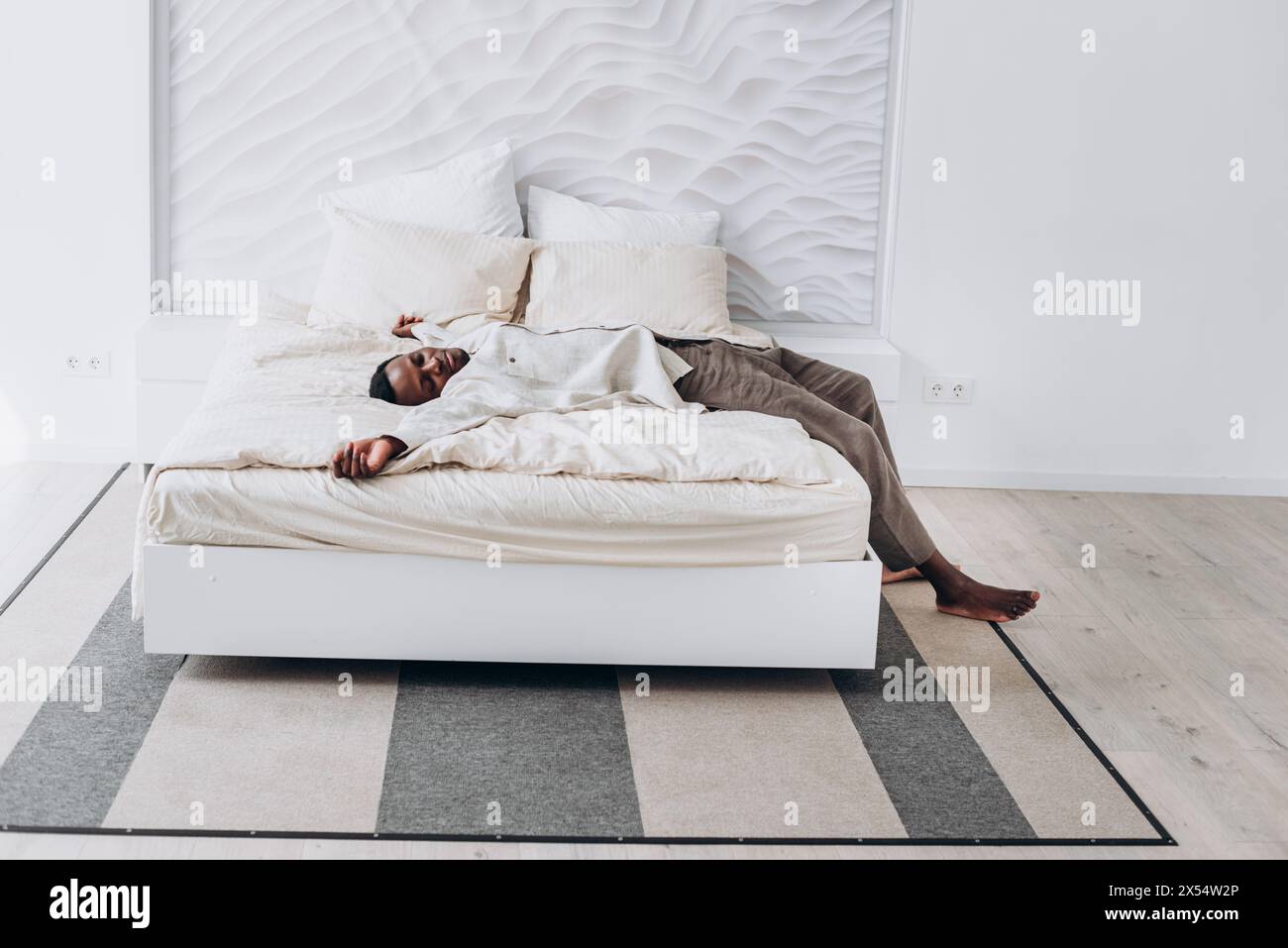 African American man enjoys a peaceful sleep in modern, minimalist ...