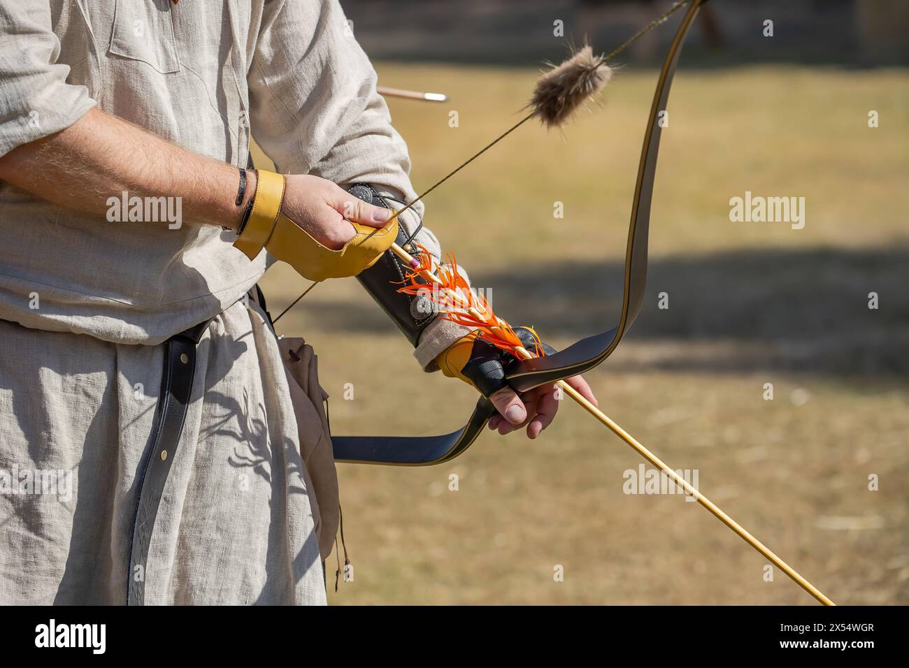 Medieval archery equipment, bow and arrow in the hands of a man ...