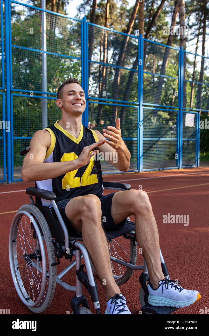 Sporty guy with disability maneuvering wheelchair engaging in ...