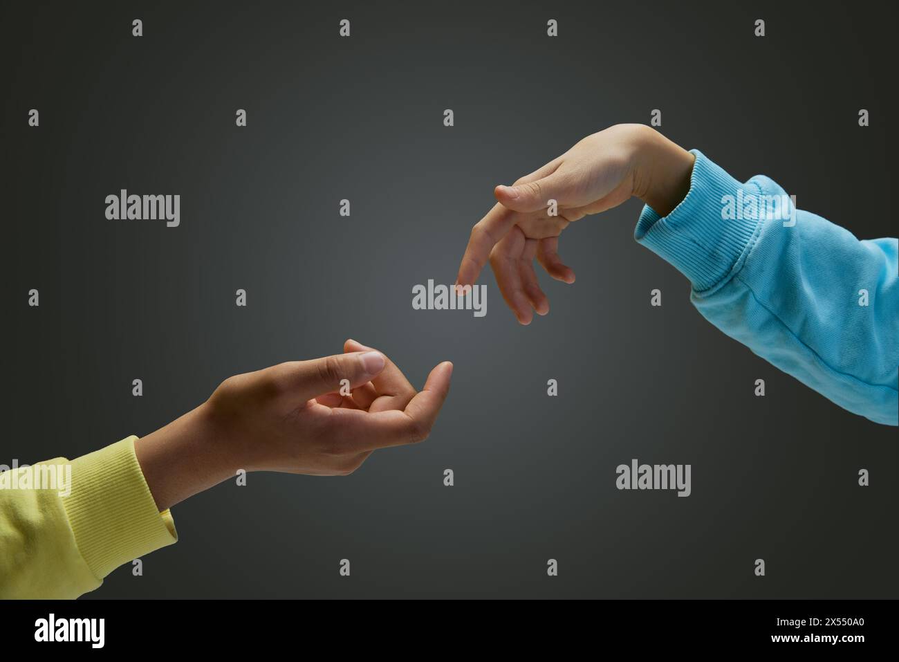 Cropped image of children's hands reaching to each other against ...