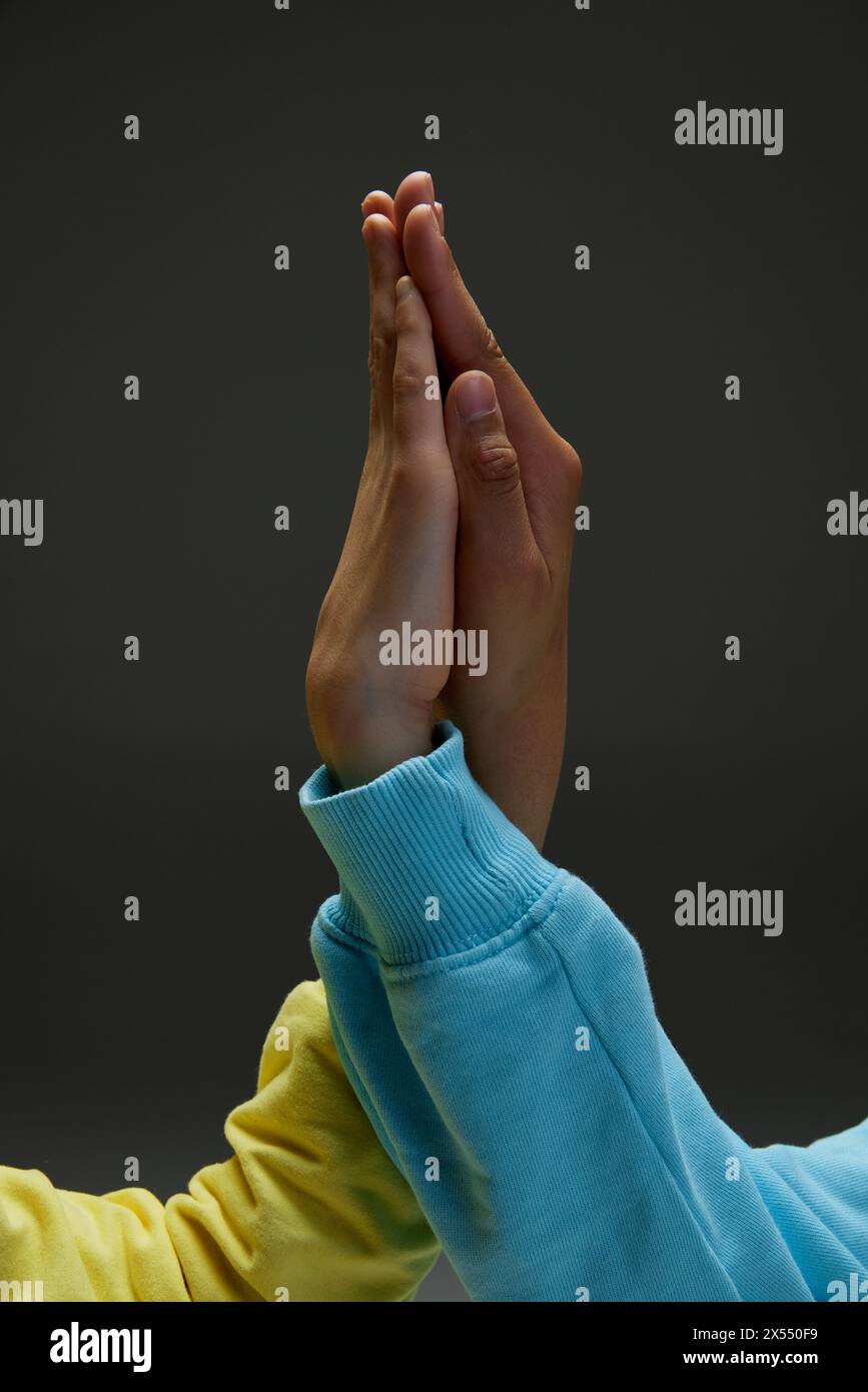 Close up of two hands pressed together palm-to-palm in a gesture of ...