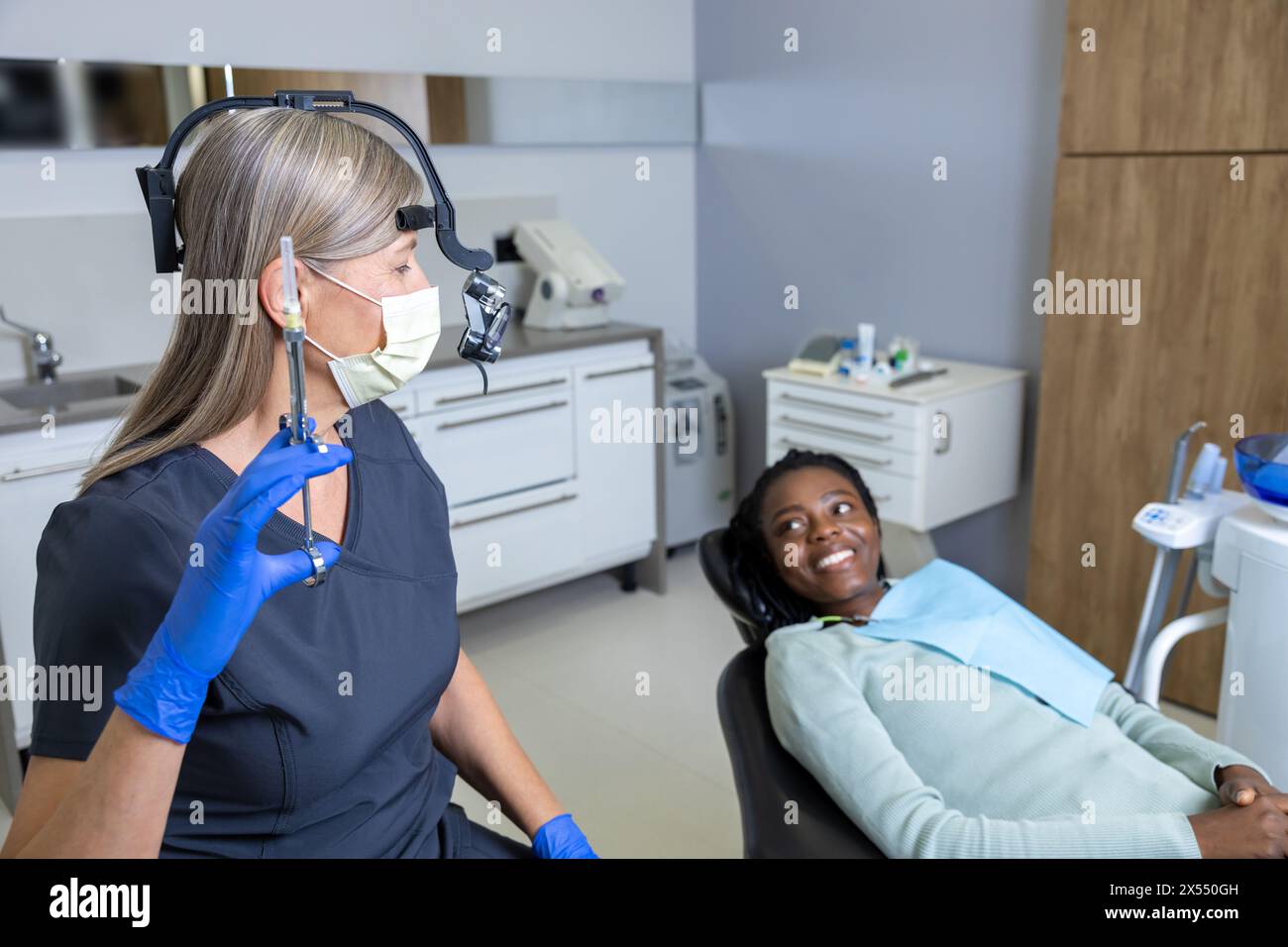 Female dentist making an anesthetic injection before tooth treatment ...