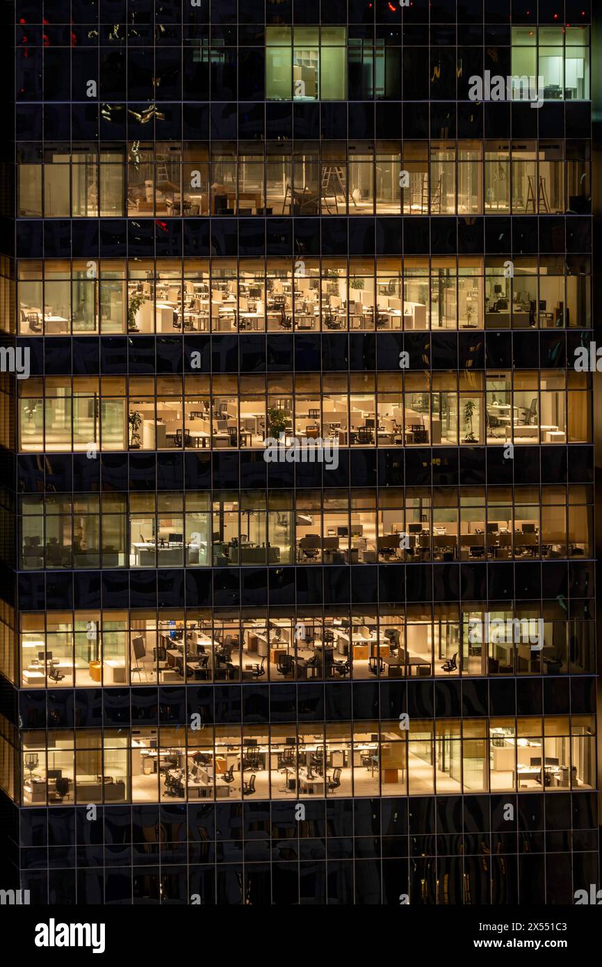 Blinking light in window of the multi-story building of glass and steel ...