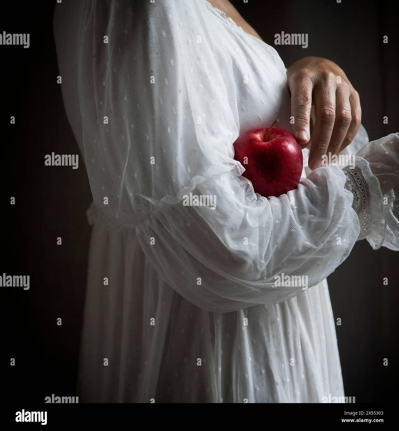 woman in white romantic style dress holding an apple in her arms Stock ...