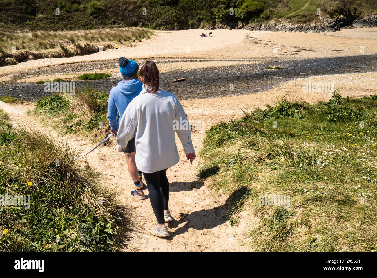 walkers on the south west coast path leading down to the secluded ...