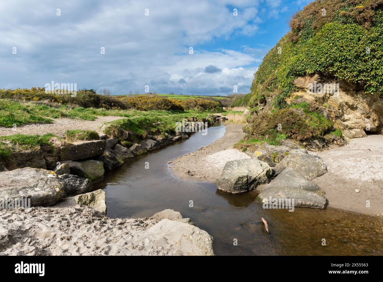 The Par Polmear River flowing towards the sea at Par Beach in Cornwall ...