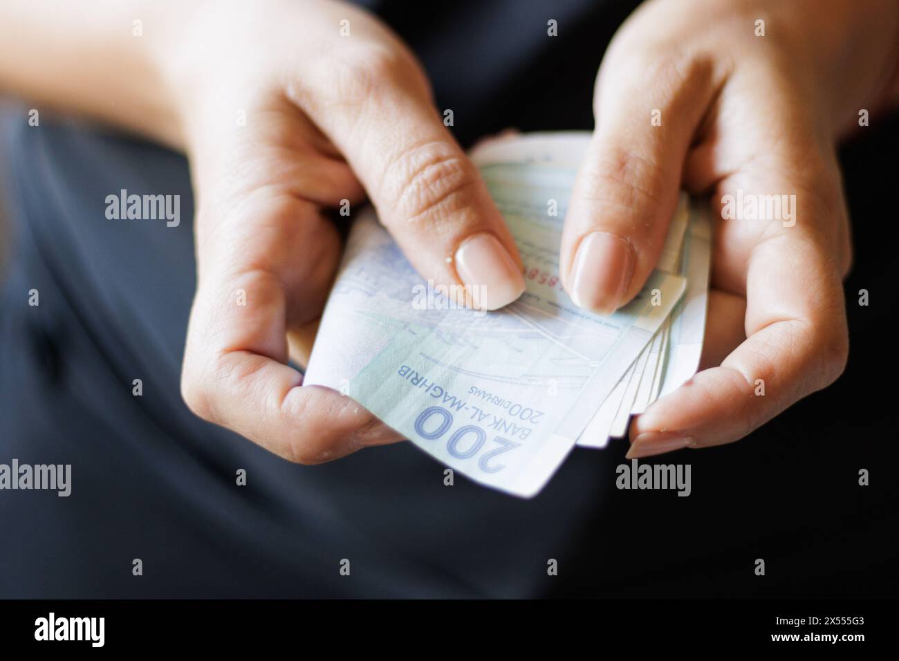 Hand holding Moroccan banknotes, dirham official currency of Morocco ...
