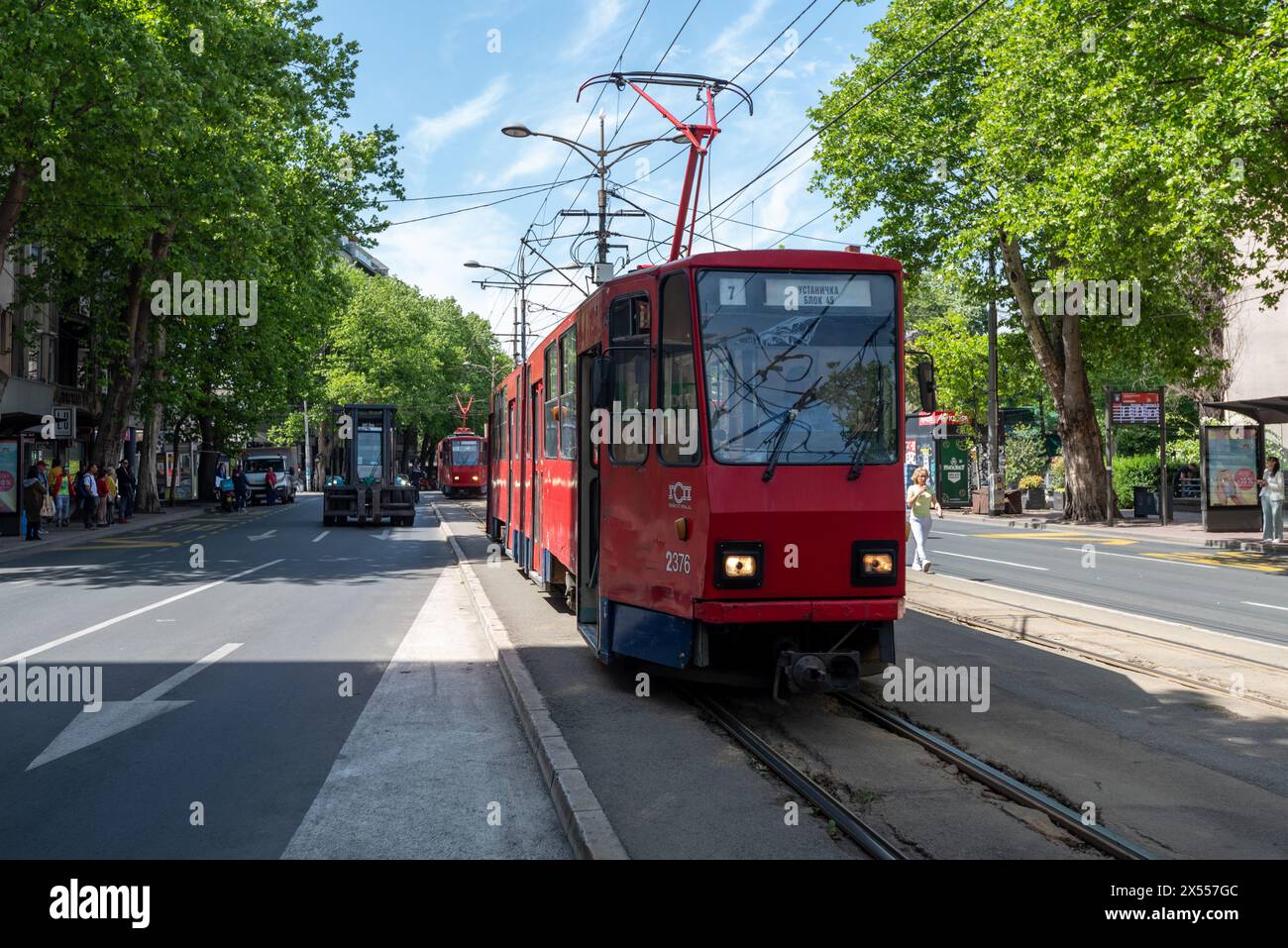 Traditional red electric trams taking passengers around the streets of ...