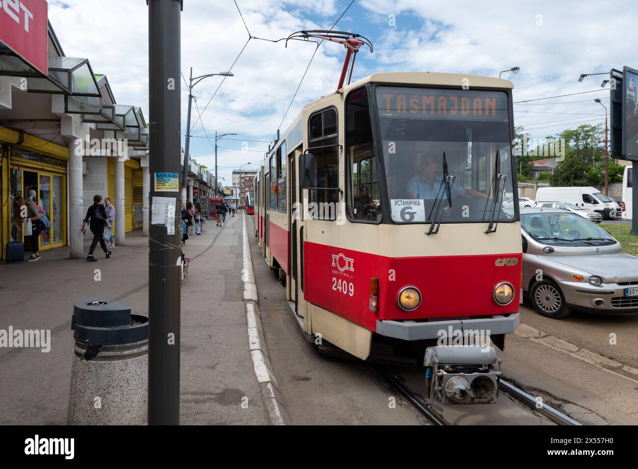 Traditional red electric trams taking passengers around the streets of ...