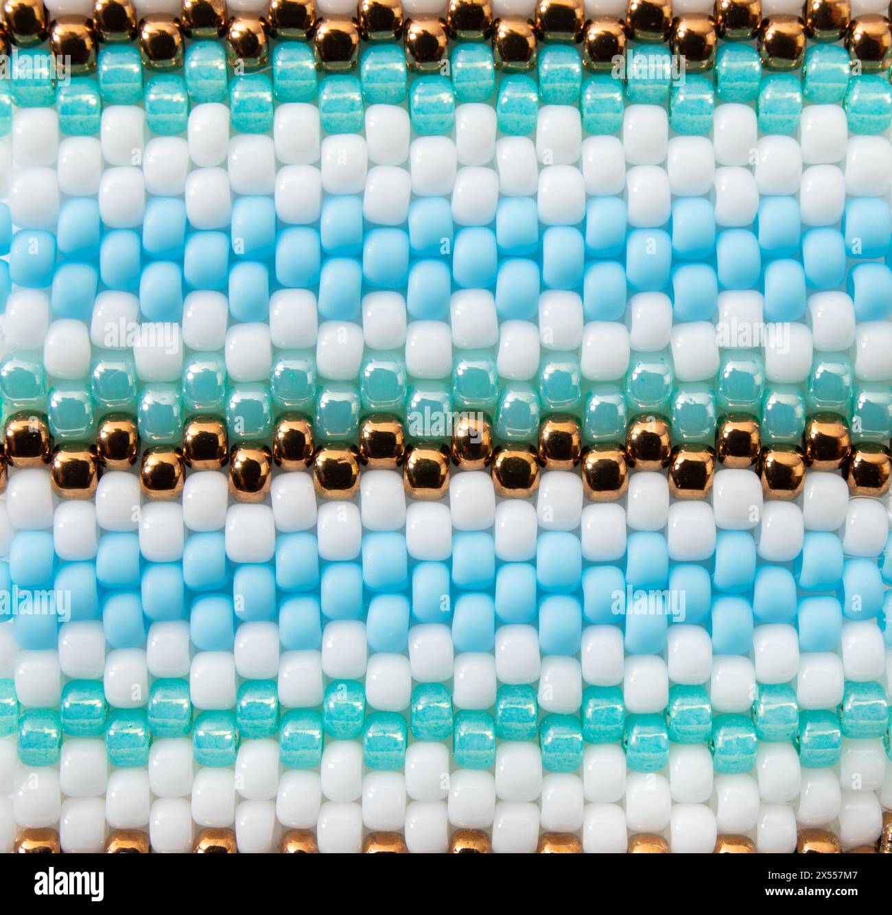 Macro shot of boho style beading backdrop. White, blue and bronze color ...