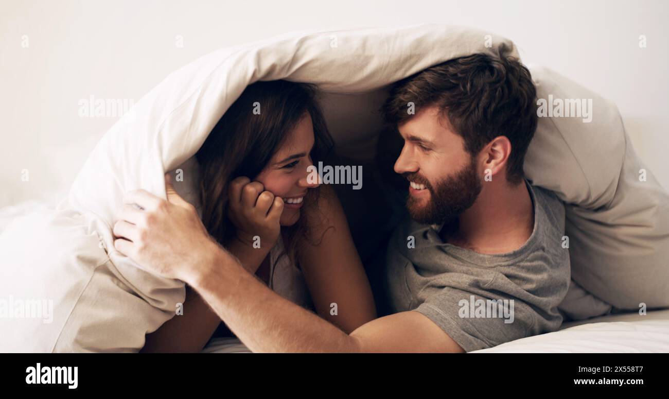 Happy, bed and couple with blanket at morning with hug at home with ...