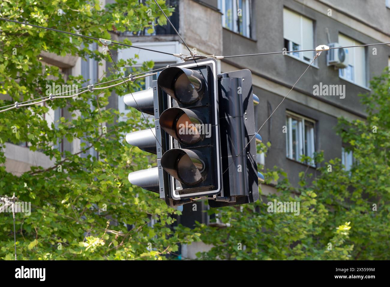 Hanging traffic lights on a street in Belgrade, with the light on amber ...