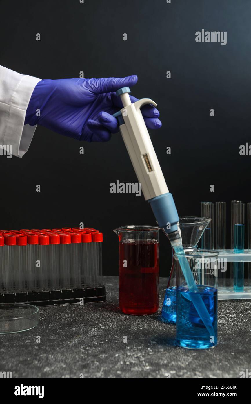 Laboratory analysis. Scientist dripping sample with micropipette into ...