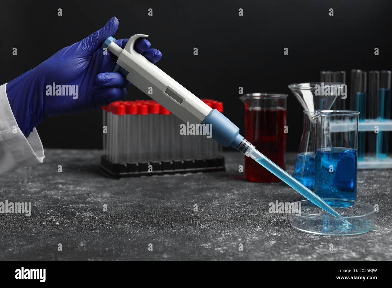 Laboratory analysis. Scientist dripping sample with micropipette into ...