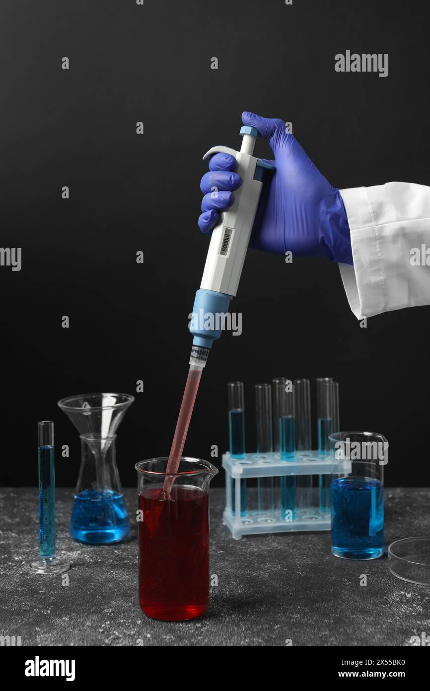 Laboratory analysis. Scientist dripping sample with micropipette into ...