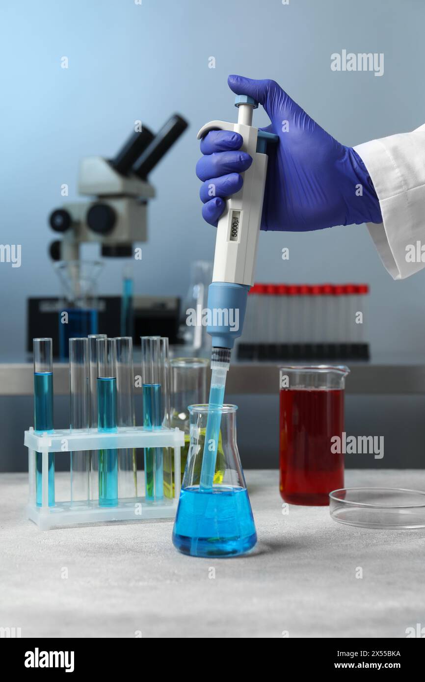 Laboratory analysis. Scientist dripping sample with micropipette into ...