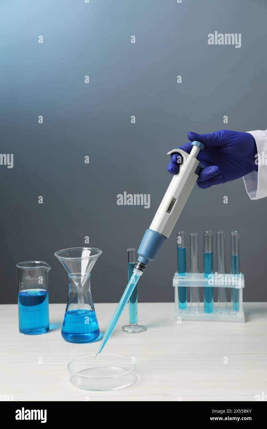 Laboratory analysis. Scientist dripping sample with micropipette into ...
