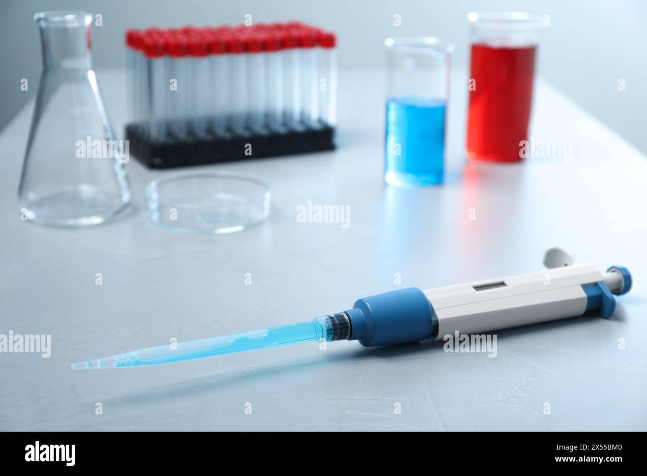 Laboratory analysis. Micropipette, beakers with liquids and other ...