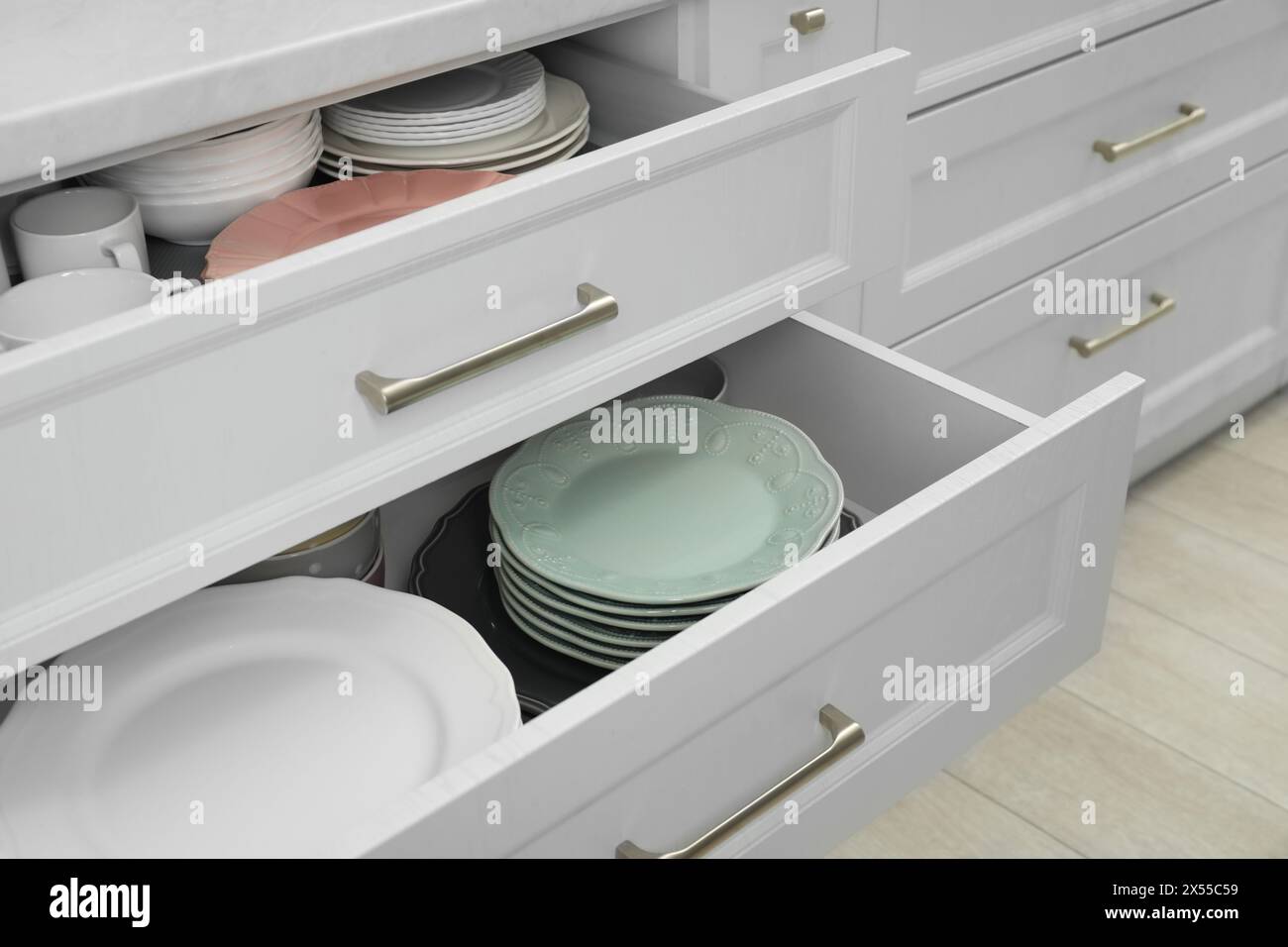Clean plates and bowls in drawers indoors Stock Photo - Alamy