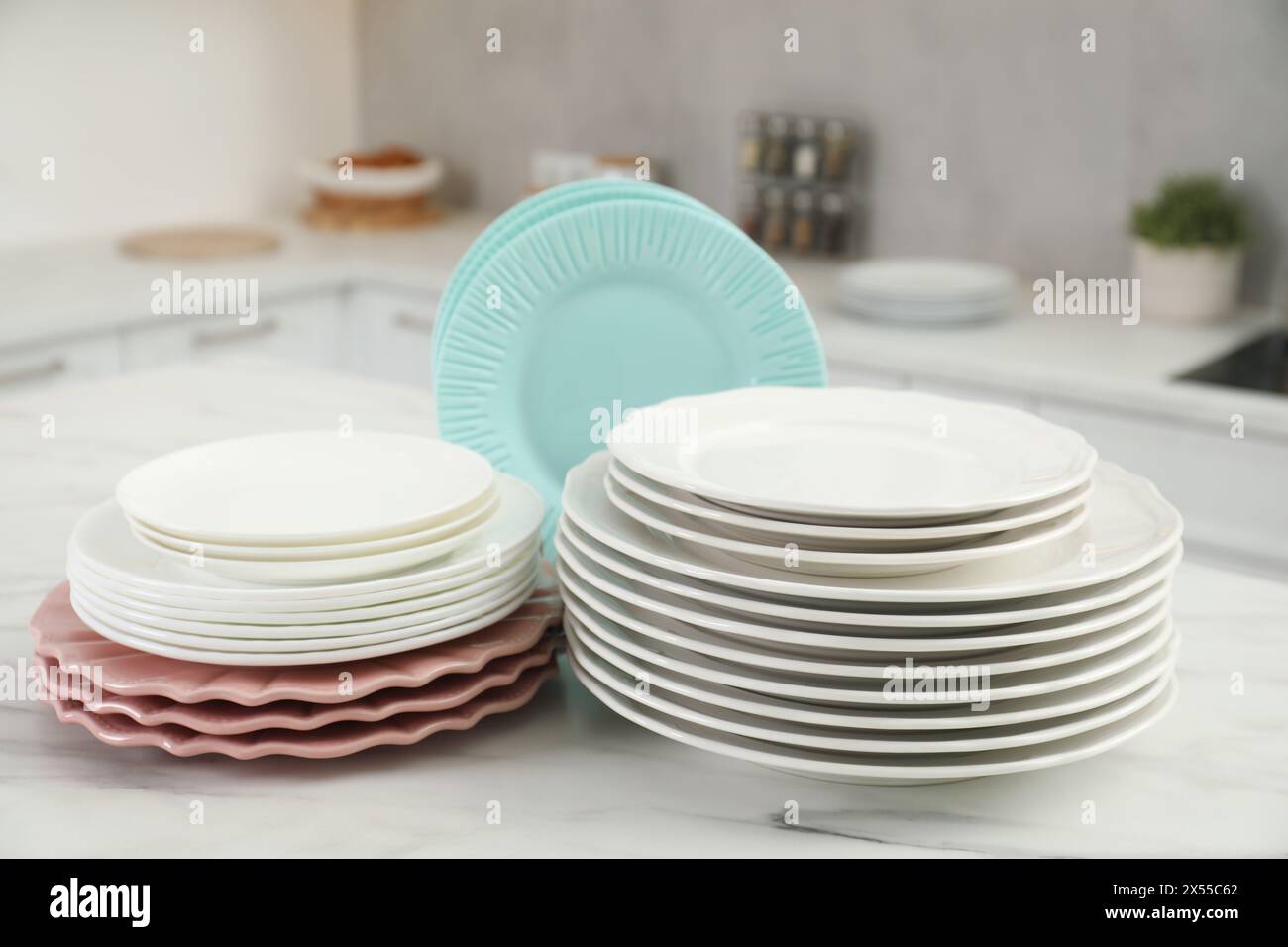 Clean plates on white marble table in kitchen Stock Photo - Alamy