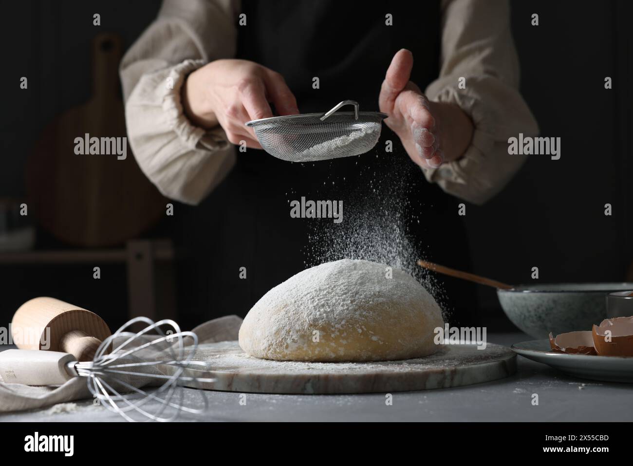 Making dough. Woman sifting flour at grey table, closeup Stock Photo ...