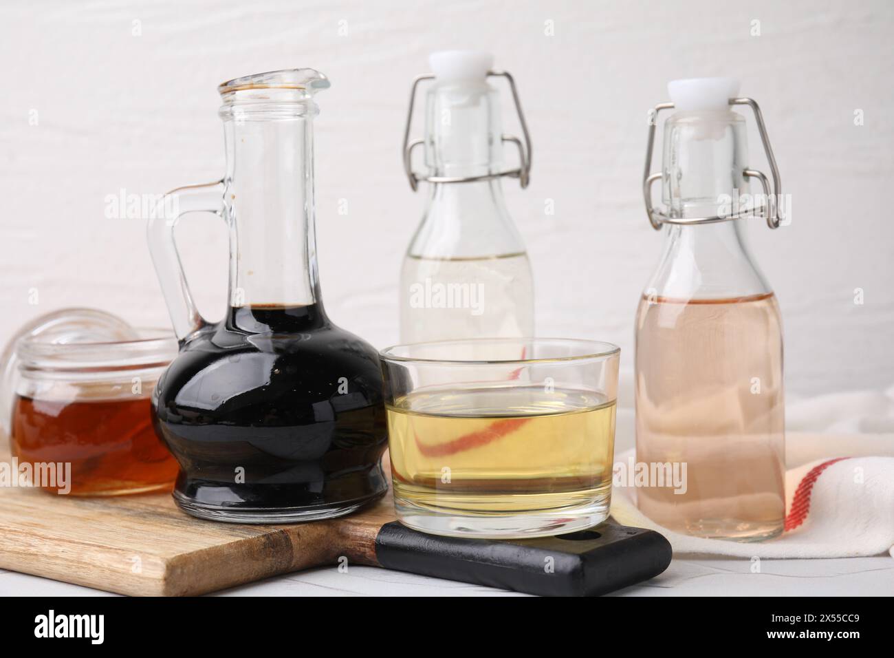 Different types of vinegar on white table Stock Photo - Alamy