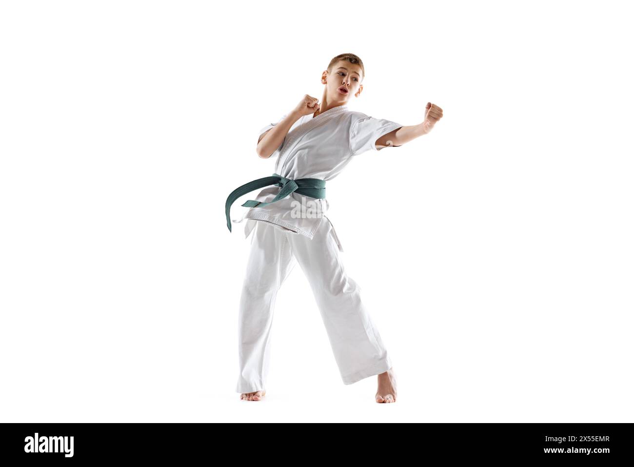 Focused teen boy, karate practitioner showing dynamic kick ...