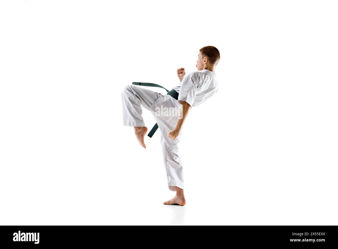Karate student in white kimono and green belt, in motion, performing ...
