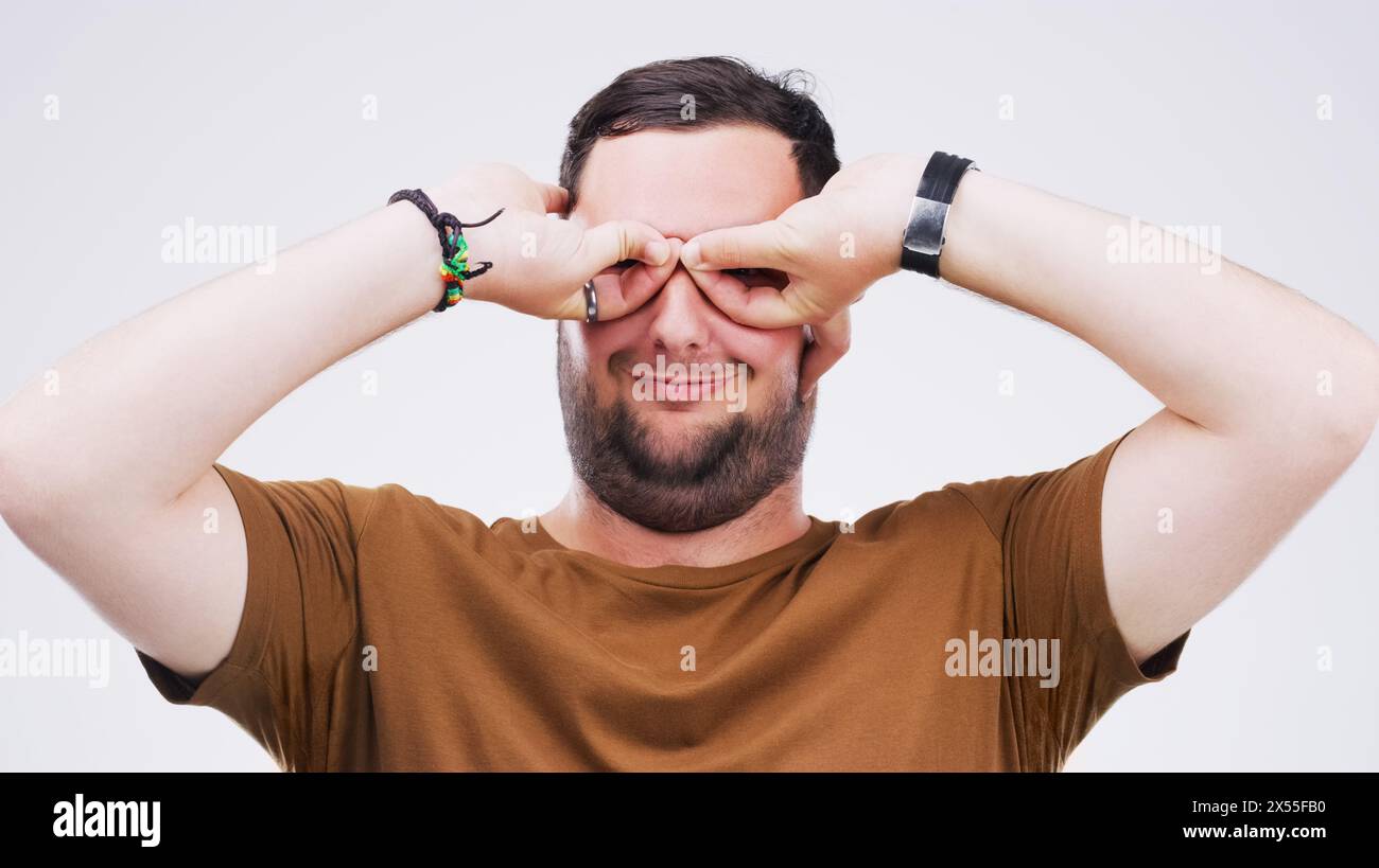 Studio, man and binoculars with hands for crazy comic, silly and goofy ...