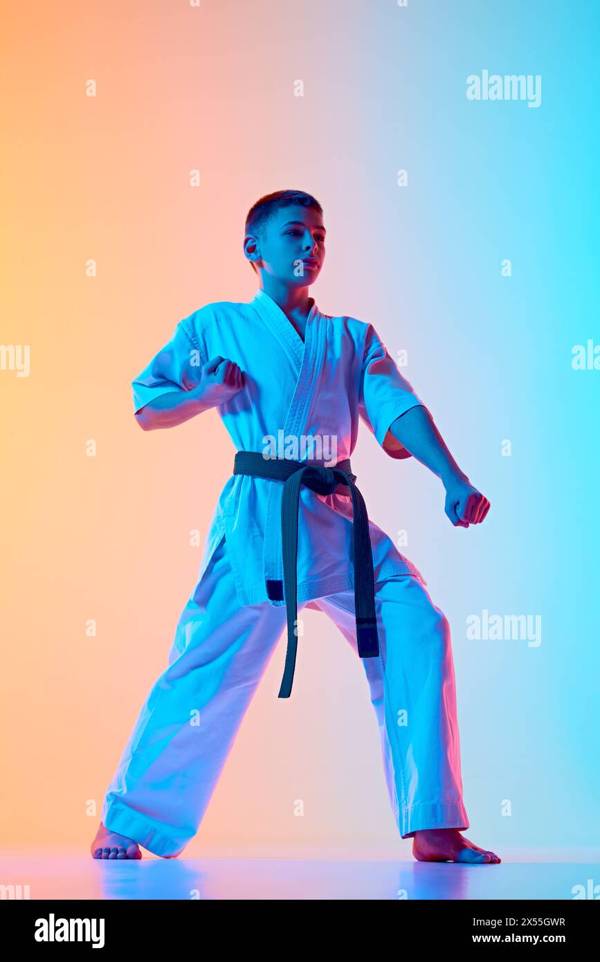 Young karateka in a defensive posture, teen boy practicing against ...