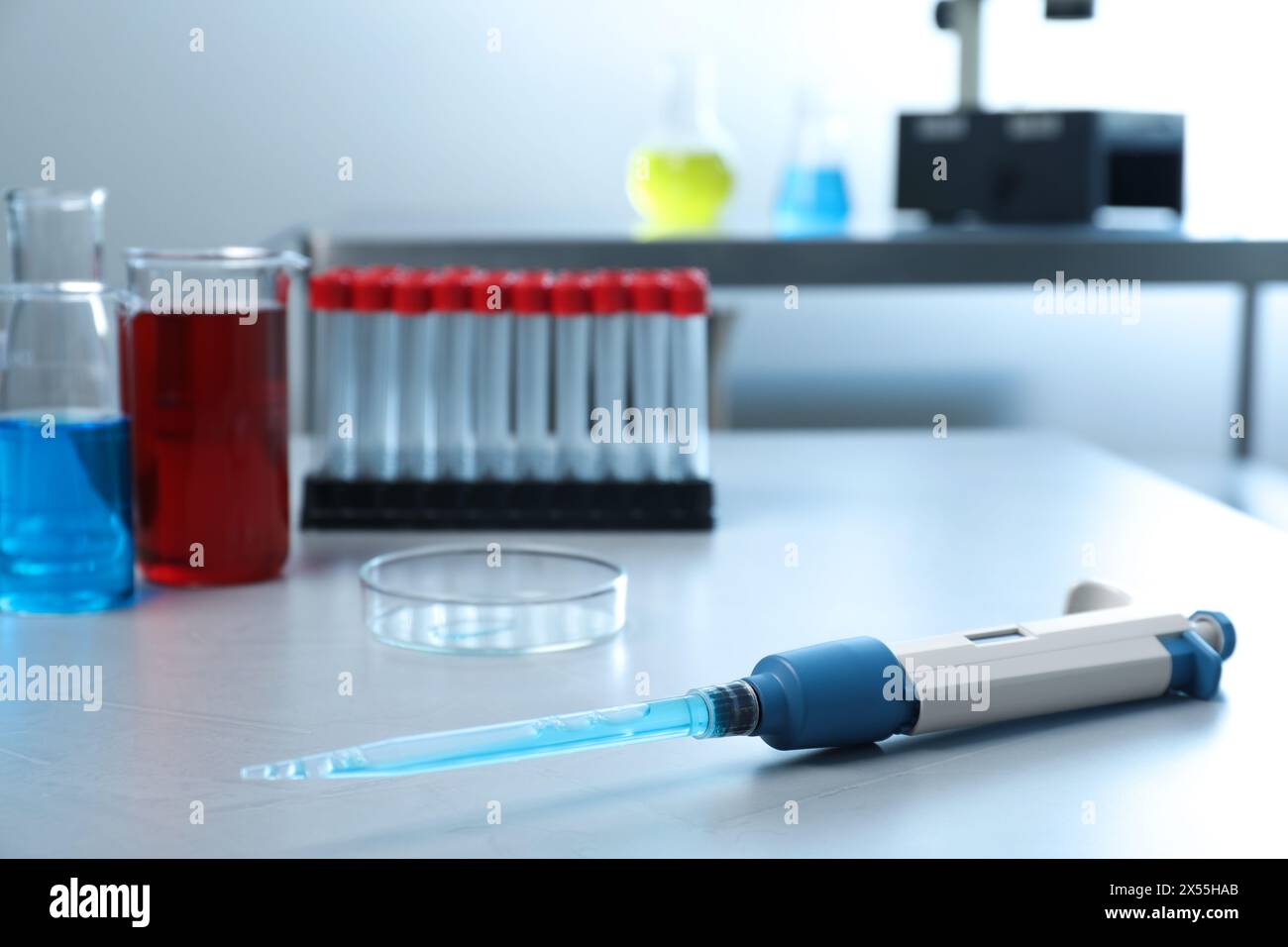Laboratory analysis. Micropipette, beakers with liquids, petri dish and ...