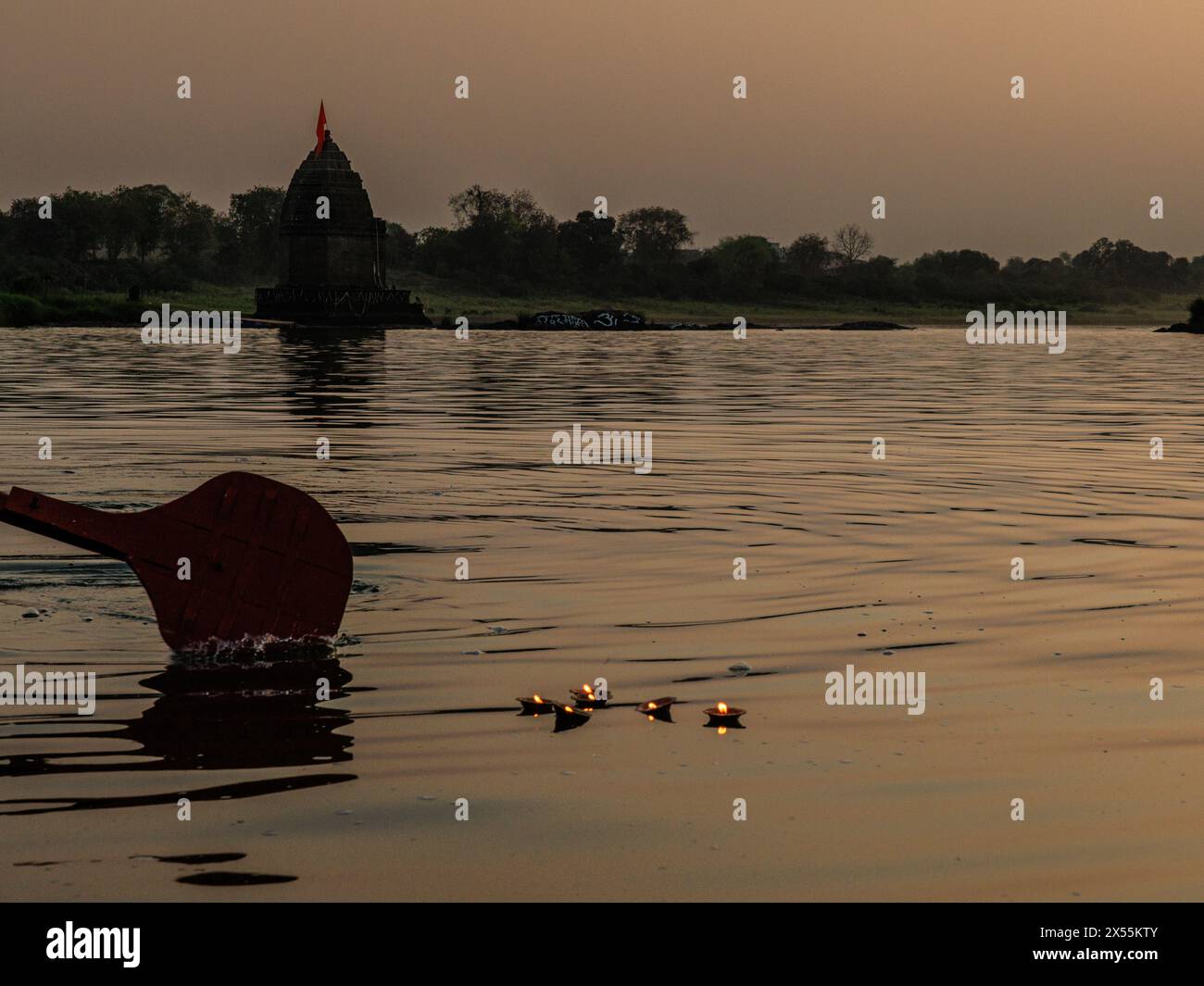 a ritual of floating lit candles in the wake of a rowing boat in the ...