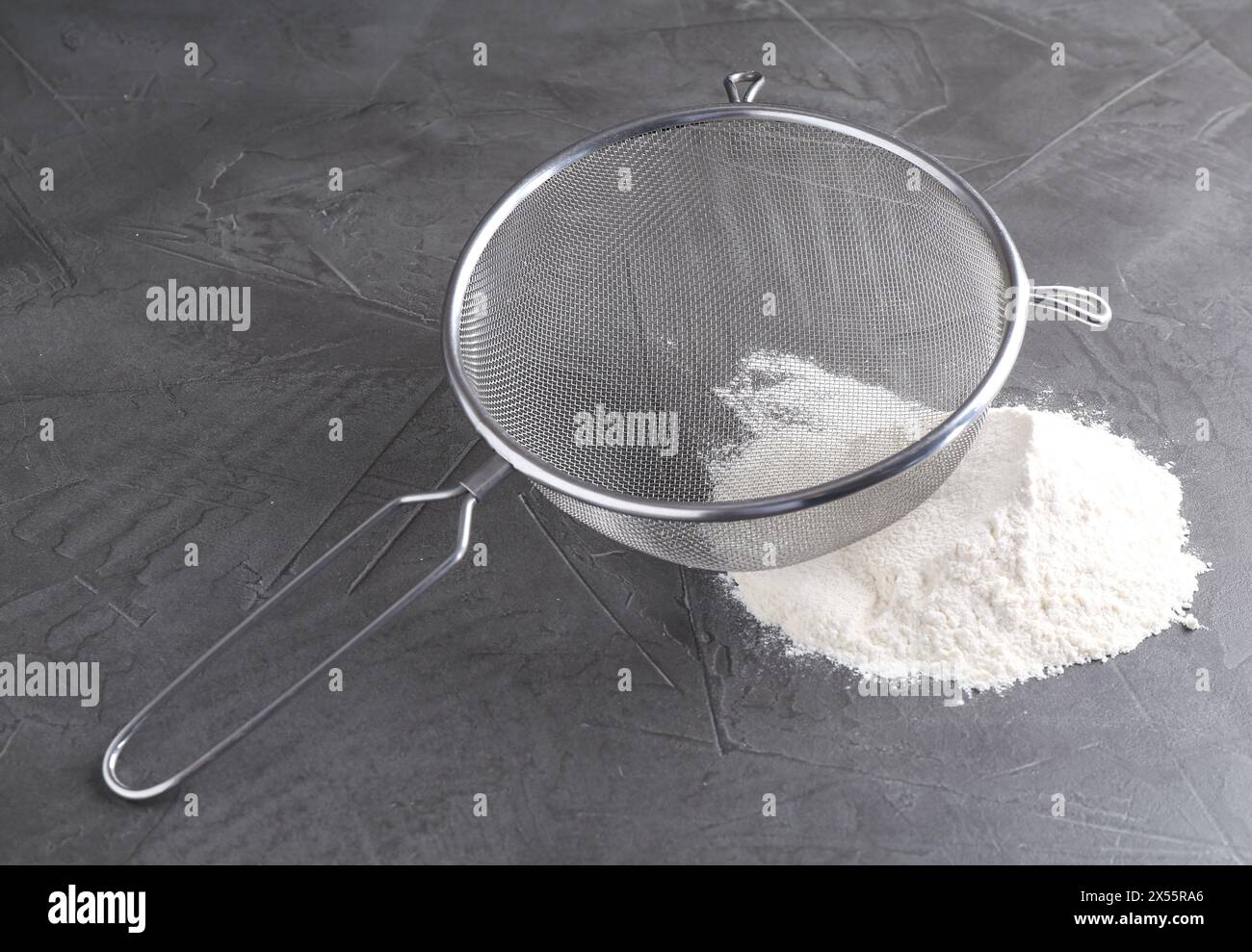 Metal sieve and flour on grey table Stock Photo - Alamy