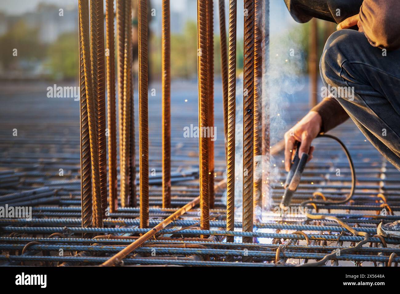 A welder welds a steel frame from reinforcement for reinforced concrete ...