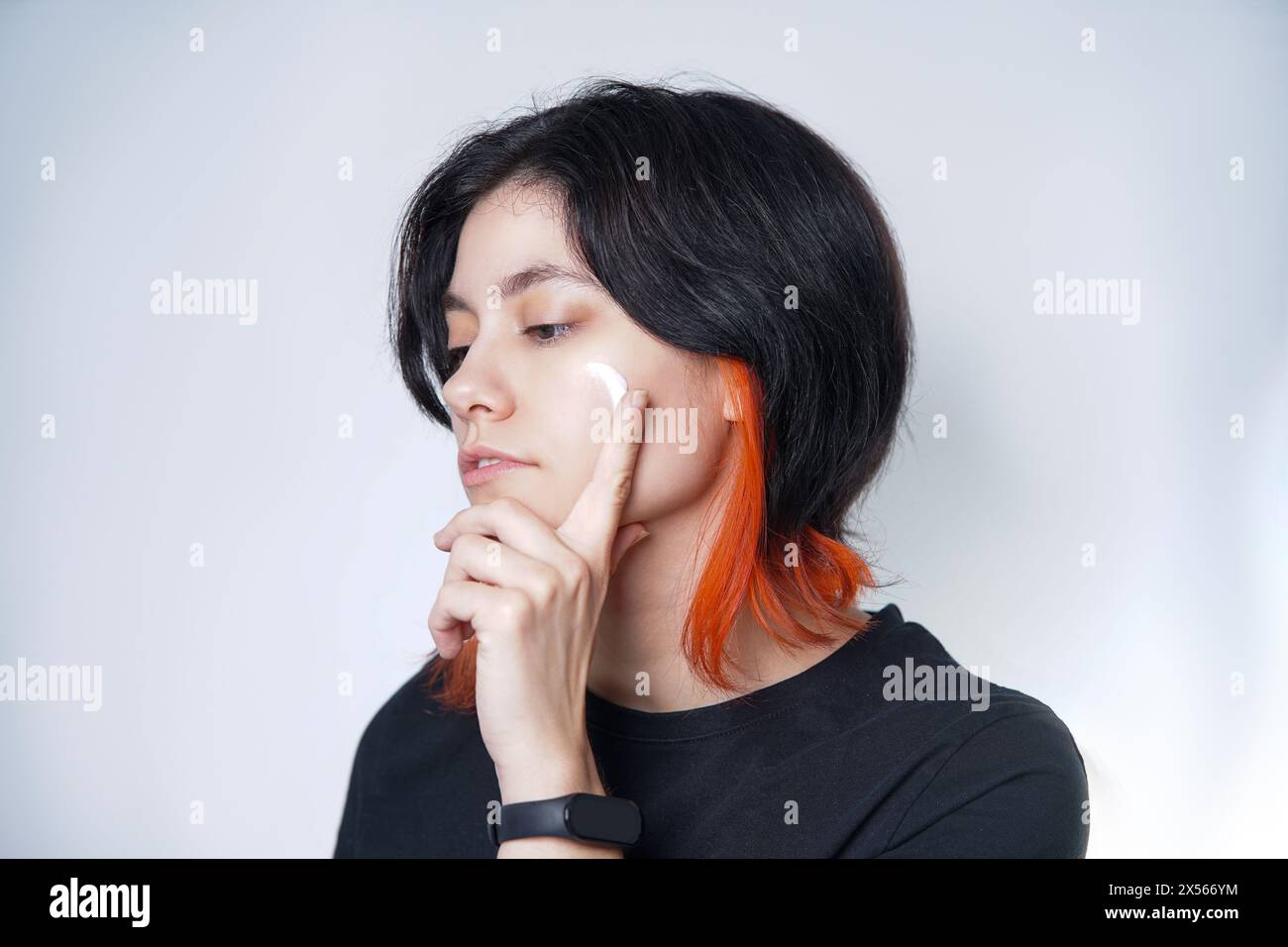 Mediterranean black and orange haired person applying a scoop of ...