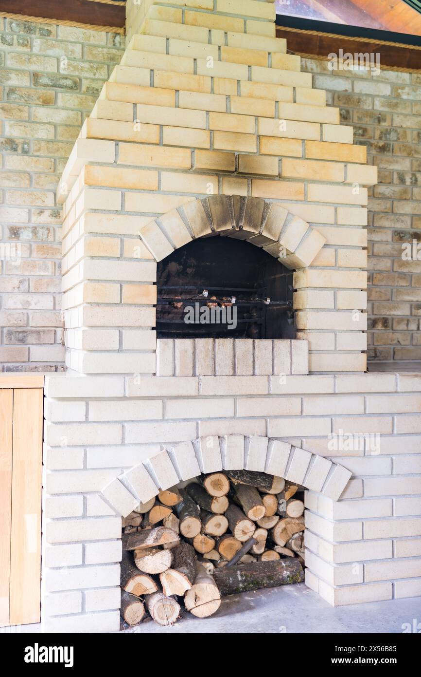 A white brick stove with soot from use, with a wood storage under the ...