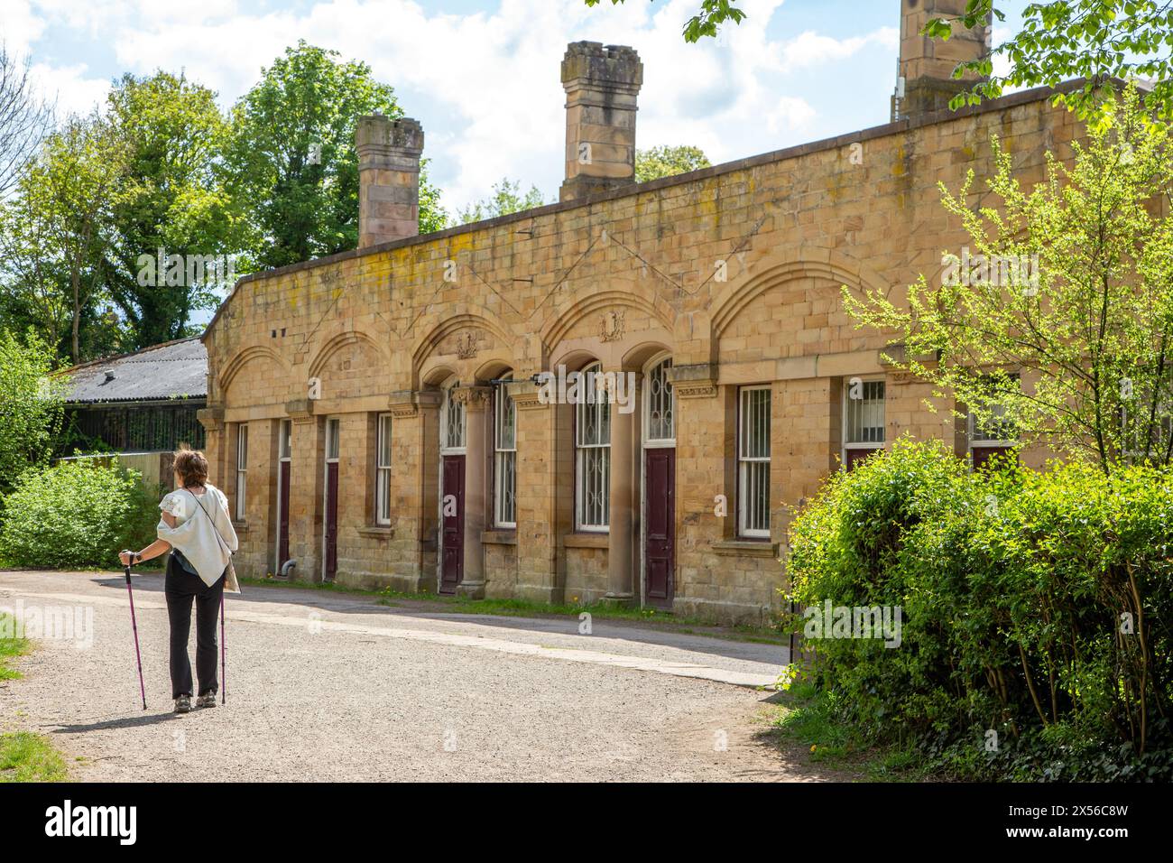 Woman walking rambling hiking past the former station building at ...