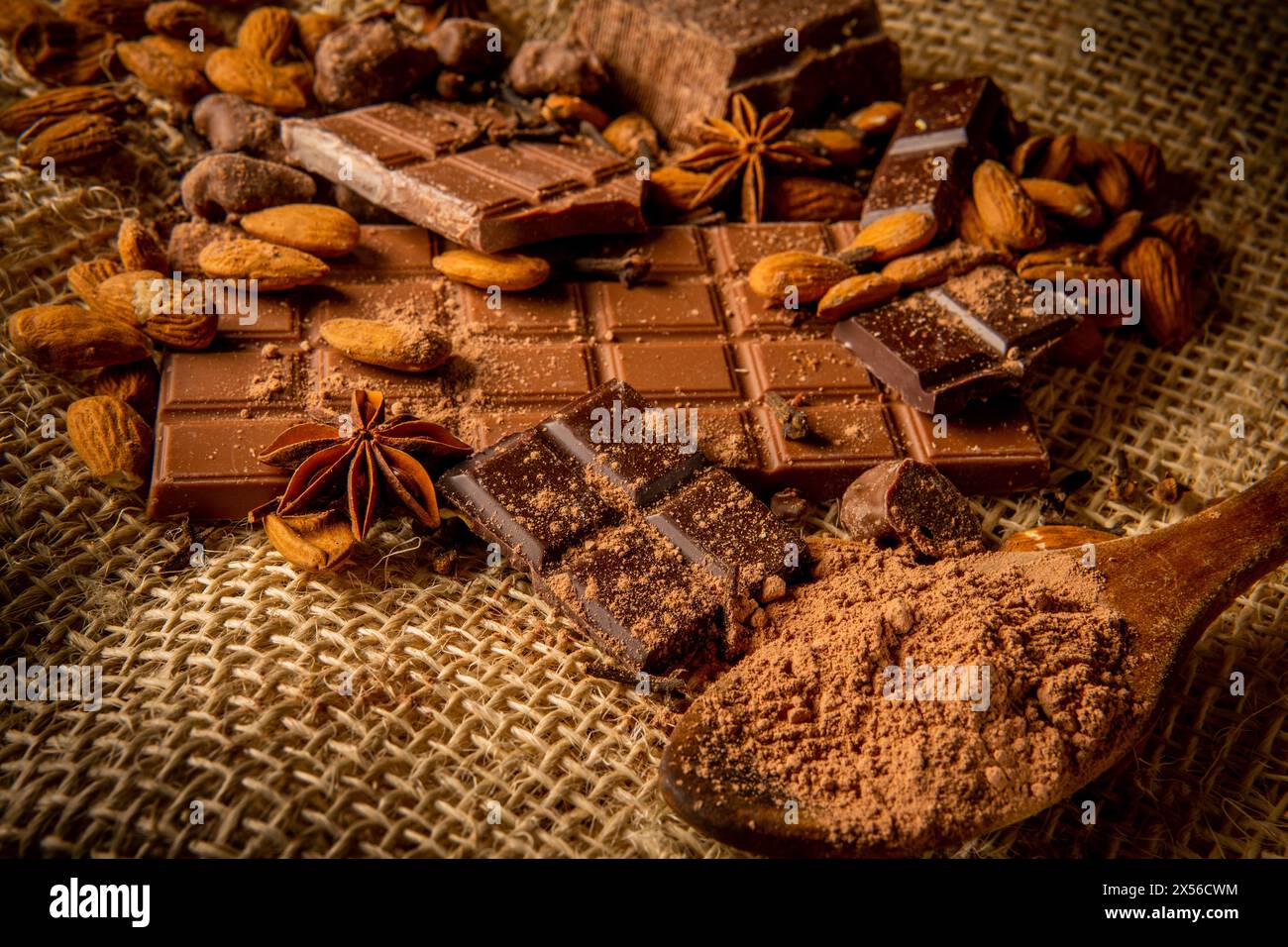 Still life of chocolate bar with cocoa powder in a ladle with almonds ...